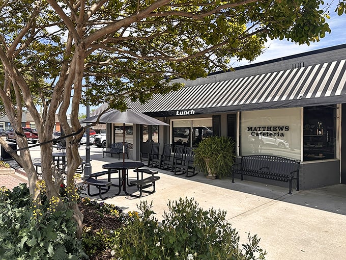 The welcoming storefront of Matthews Cafeteria, where rocking chairs invite you to sit a spell before diving into Southern comfort food heaven.