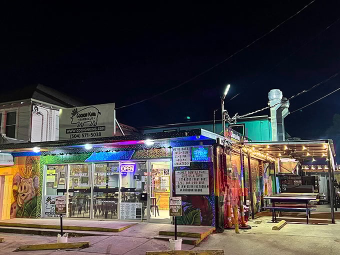 Cochon King's nighttime exterior glows like a neon-lit barbecue beacon, promising smoky treasures within its colorfully muraled walls.