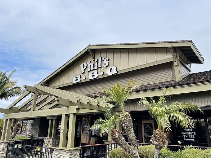 The California sun plays peekaboo with Phil's BBQ's iconic façade, where palm trees stand guard over what might be San Diego's most aromatic parking lot.