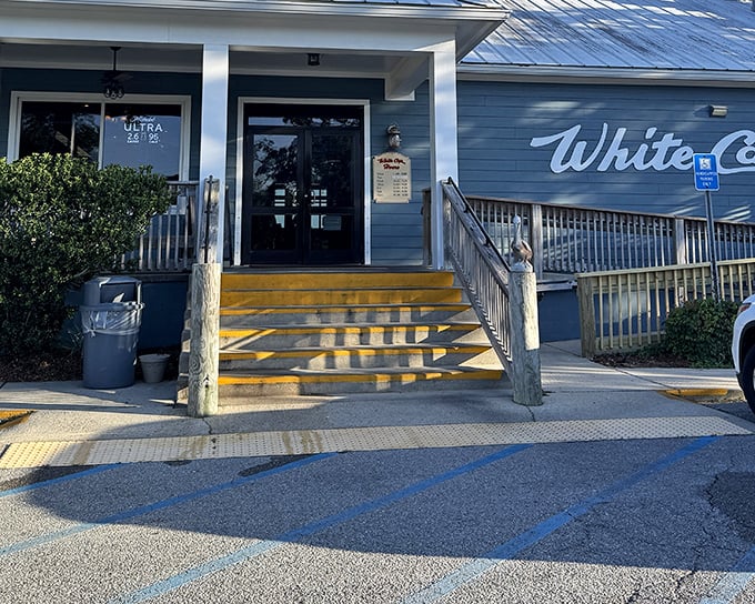 Those yellow steps aren't just stairs – they're your gateway to seafood paradise. The blue exterior of White Cap welcomes hungry souls with coastal charm.