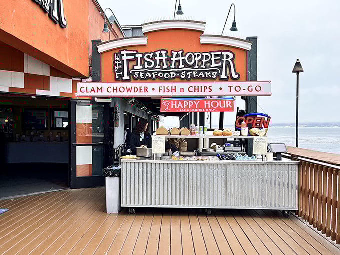 The vibrant orange facade of Fish Hopper stands like a cheerful sentinel on Cannery Row, promising seafood treasures with a side of Pacific views.