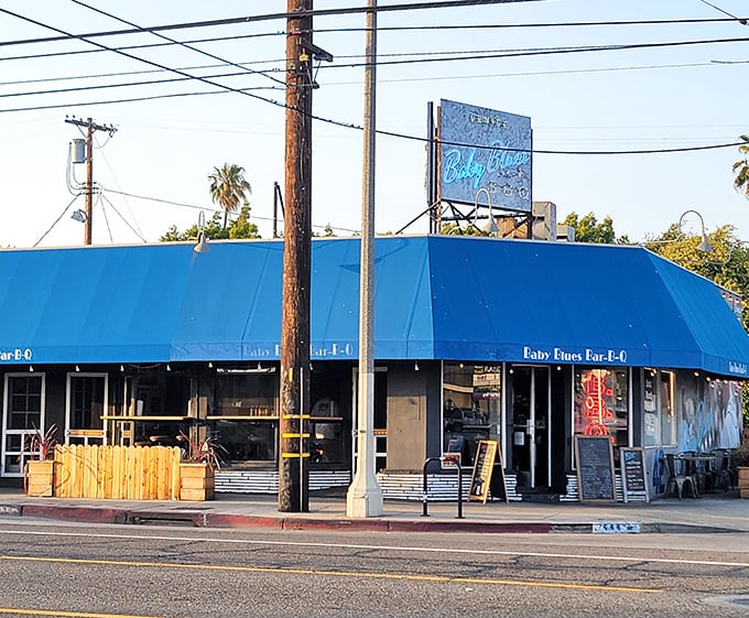 A California sunset frames Baby Blues BBQ's iconic blue awning – proof that sometimes paradise smells like smoke and tastes like heaven.
