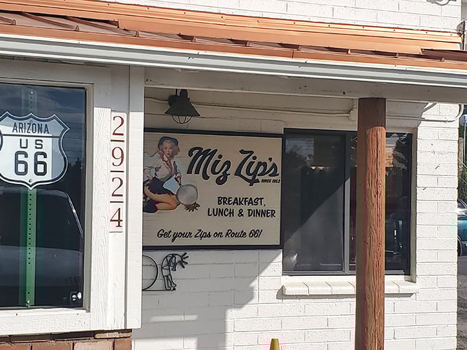 The promise of roadside bliss! Miz Zip's iconic Route 66 storefront beckons hungry travelers with its charming vintage sign and irresistible slogan.
