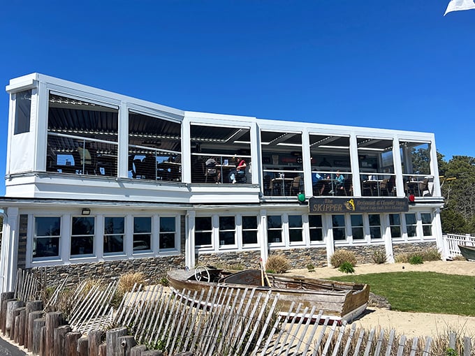 Cape Cod architecture at its finest—weathered beach fencing below, panoramic ocean views above, and seafood magic happening inside.