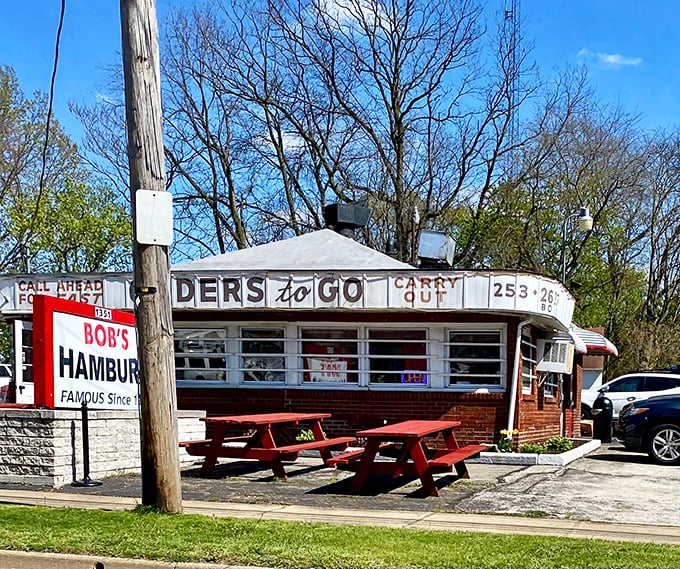 This little white building with its vintage "ORDERS to GO" signage isn't just a restaurant—it's a time machine with burgers.