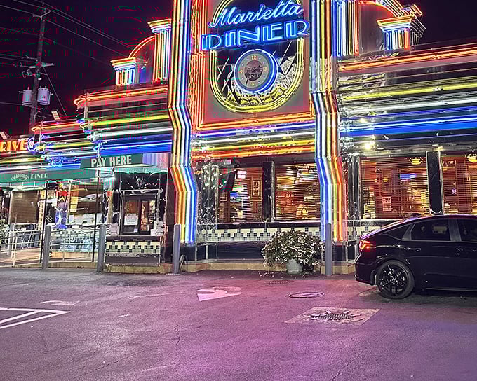 The neon rainbow exterior of Marietta Diner at night isn't just a restaurant sign—it's a beacon calling hungry souls home at any hour.