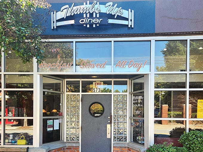 The iconic blue facade of Thumbs Up Diner promises "Breakfast Served All Day!" – words that should be carved into the Mount Rushmore of culinary comforts.