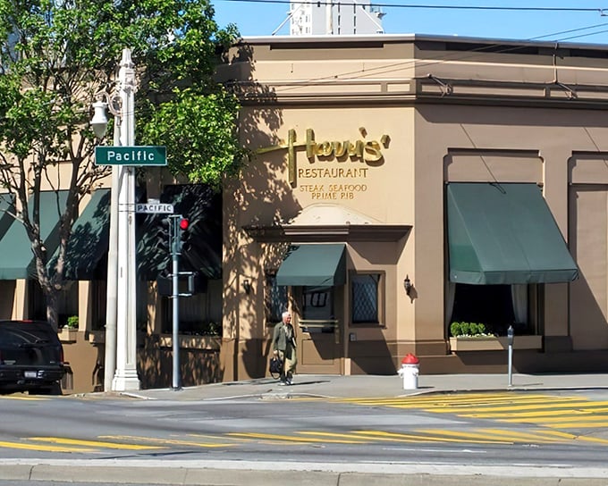 The elegant cream exterior with signature green awnings stands as a beacon of culinary tradition on Van Ness Avenue, promising carnivorous delights within.