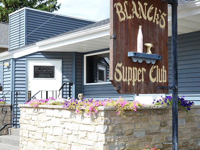 The rustic wooden sign against the blue siding says it all – this isn't fancy dining, it's Wisconsin comfort at its finest.