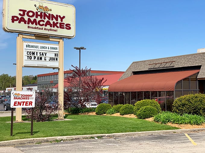 The iconic Johnny Pamcakes sign promises "Breakfast Anytime!" – three words that should be enshrined in the culinary hall of fame. The red awning beckons like an old friend waving you in. 