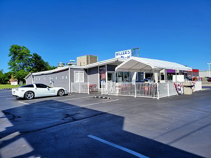 Miller's Drive-In stands as a beacon of nostalgia in Bellevue, its modest gray exterior and white picket fence promising honest food and sweeter memories.