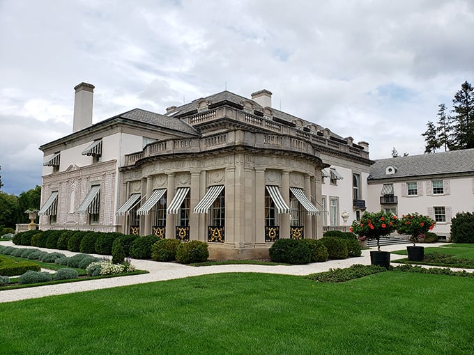 Nemours Estate's gleaming limestone façade and jaunty striped awnings—where Versailles meets Delaware in 77 rooms of pure architectural swagger.