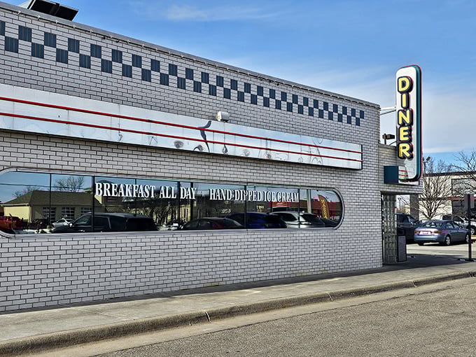 The classic white-tiled exterior with its bold neon "DINER" sign isn't just advertising – it's a promise of American comfort food perfection waiting inside.