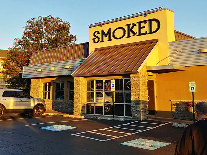 The bright yellow exterior of Smoked Bar & Grill stands like a beacon for barbecue pilgrims, promising smoky treasures within those stone-accented walls.