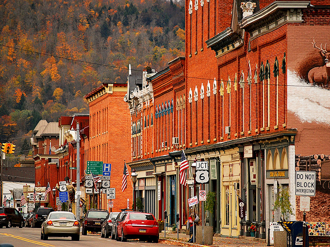 Main Street Coudersport in autumn glory – where brick buildings stand proudly against nature's most spectacular color show. Small-town America at its picturesque best.
