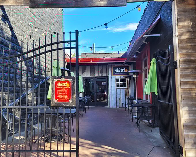 The purple-hued entrance to Meat BBQ beckons like a smoky siren call, with colorful string lights promising delicious adventures within.