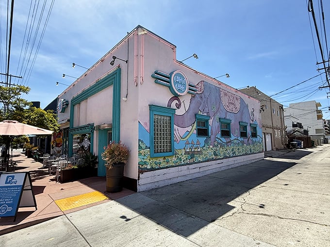 The pink and turquoise exterior of Crest Cafe stands out like a cheerful postcard from the 1950s, complete with a whimsical elephant mural that seems to say "come hungry."