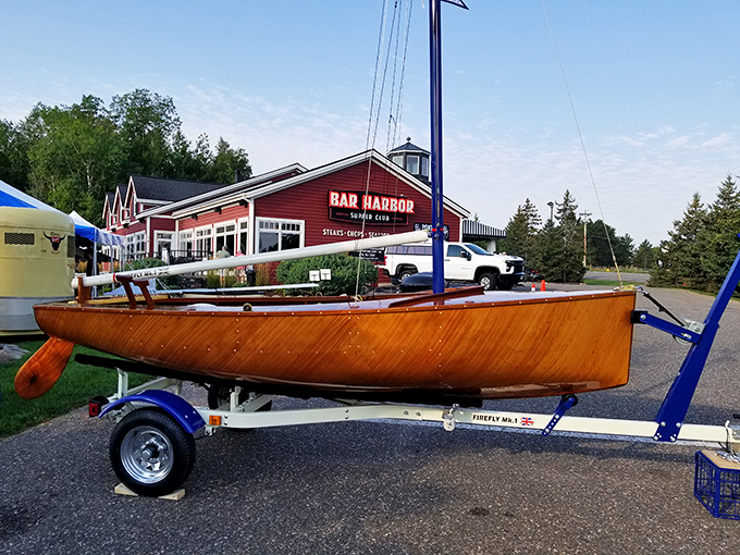 A wooden sailboat parked outside Bar Harbor—because in Minnesota, even the landlocked restaurants deserve a proper nautical entrance.