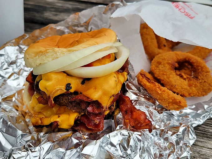 This isn't just a bacon cheeseburger—it's architecture, engineering, and art all stacked between two buns with onion rings as the perfect sidekick.