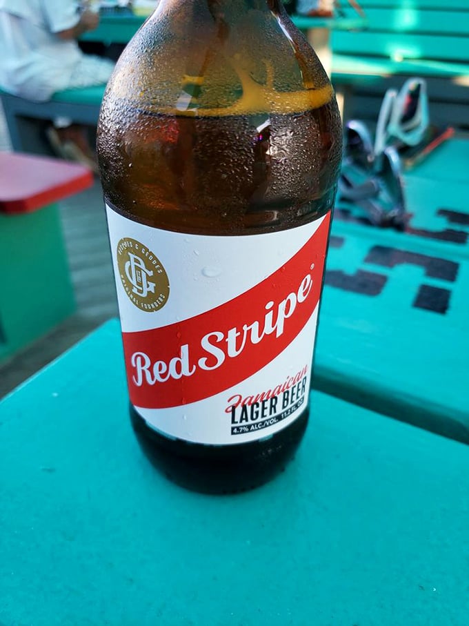 A cold Red Stripe against a turquoise table—sometimes the simplest pleasures are the most profound, especially after a day in the Florida sun.