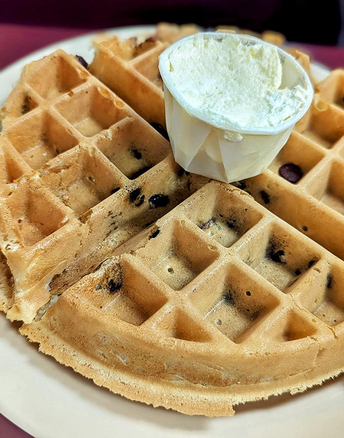 This Belgian waffle isn't just breakfast—it's architecture with deep pockets perfectly designed to hold rivers of butter and maple syrup.