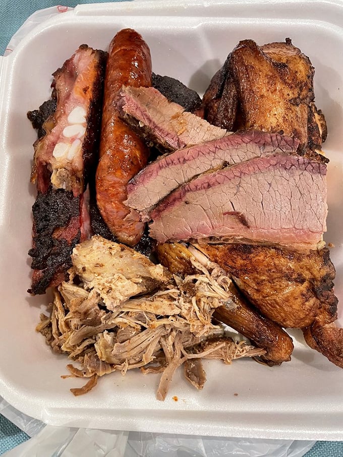 The BBQ trinity – brisket with that pencil-thin smoke ring, sausage with snap, and pulled pork that's clearly been introduced to smoke properly.