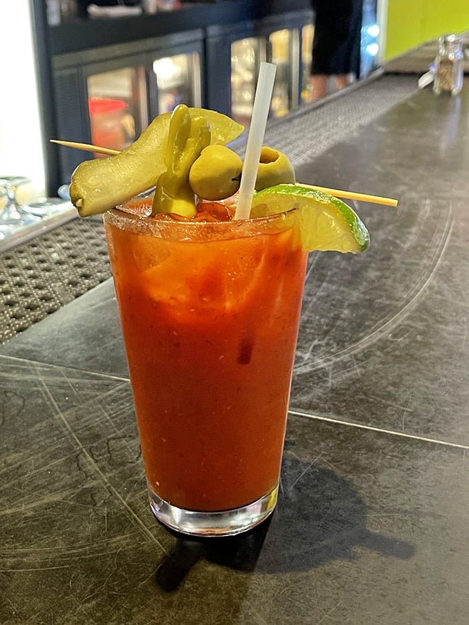The Bloody Mary arrives garnished like it's ready for battle—pickles and olives standing at attention. Breakfast, lunch, and courage in one glass.