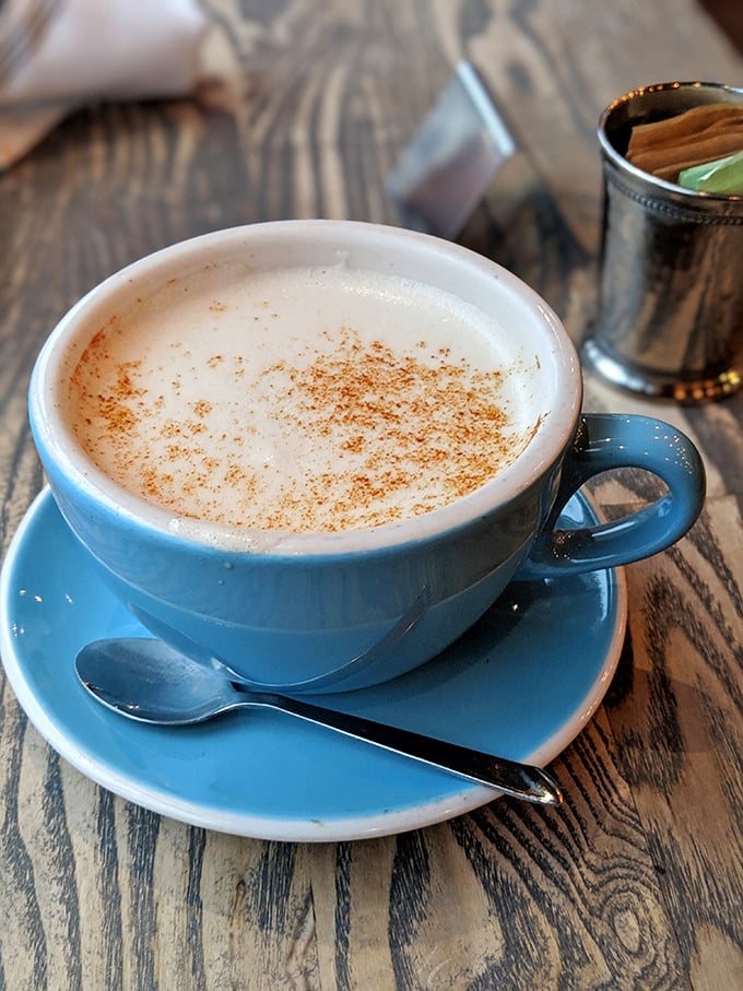 This isn't just coffee—it's a blue ceramic cup of morning motivation, dusted with cinnamon and served with a side of "now I can face the day."