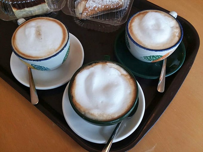 Three perfectly crafted cappuccinos, their foam art intact—the coffee equivalent of a Renaissance triptych, ready to transform an ordinary afternoon into something special.