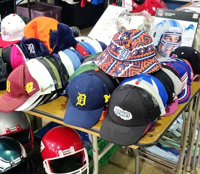 Detroit pride caps mingle with vintage helmets in a display that captures Michigan's undying loyalty to its beloved sports teams.