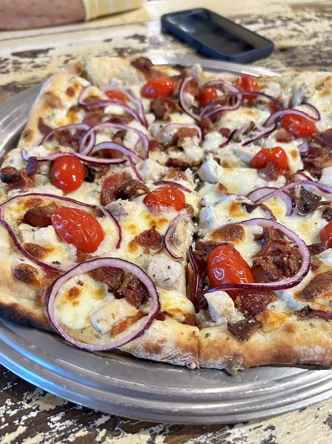 Red onions and cherry tomatoes add pops of color to this pizza canvas—proof that sometimes the simplest ingredients create the most memorable bites.