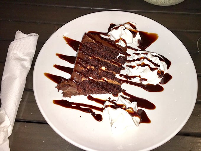 Death by chocolate? If so, what a way to go—layers of rich cake and frosting drizzled with sauce and topped with clouds of whipped cream.