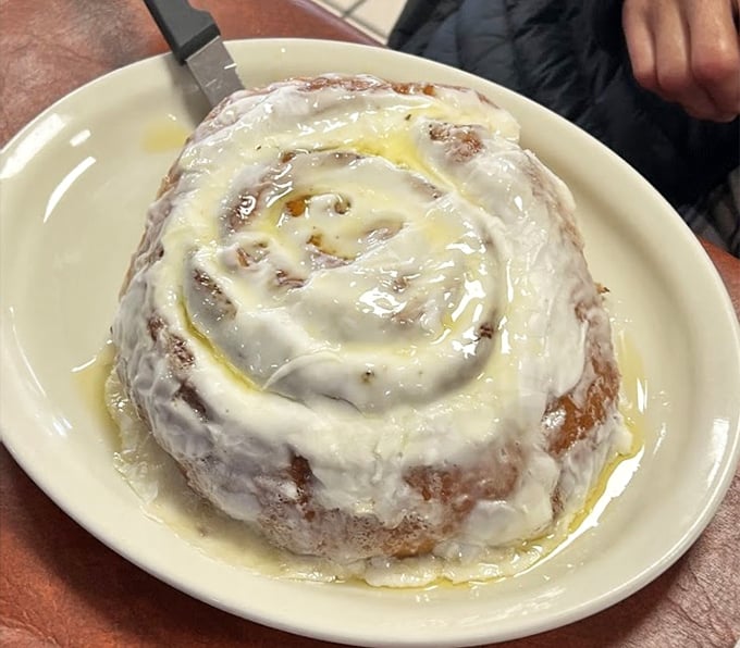 This cinnamon roll isn't just breakfast—it's dessert masquerading as a morning meal, glazed with enough sweetness to power your entire day.