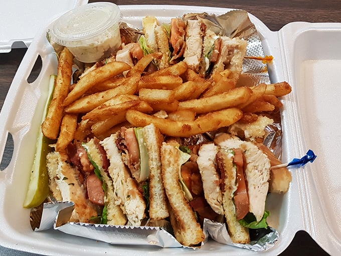 The club sandwich—that architectural marvel of toast, meat, and vegetables—served with a mountain of fries that demands to be shared.