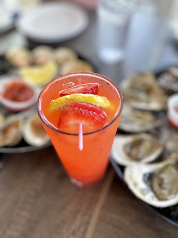 A coral-hued cocktail that tastes like summer vacation in liquid form. Those oysters in the background are whispering, "Pick me next!" 