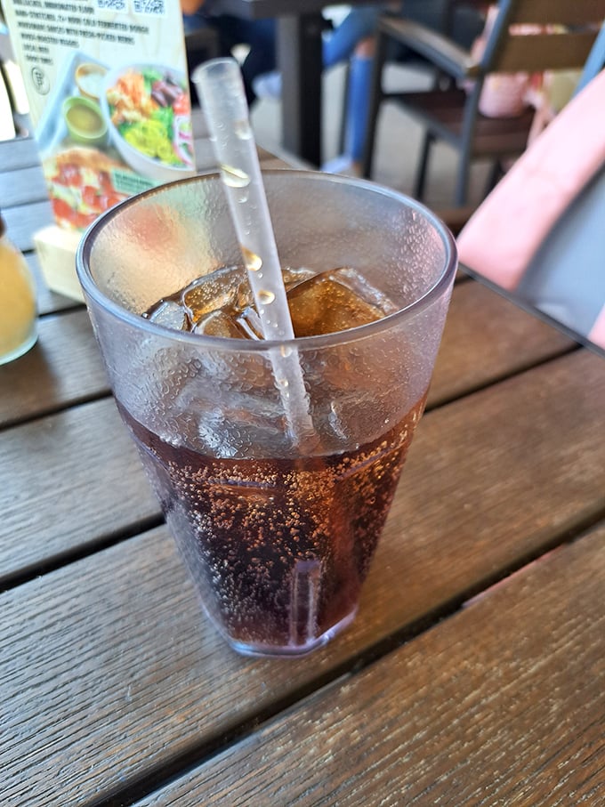 In Florida heat, this sweating glass of cola isn't just a beverage—it's survival equipment with the bonus of washing down pizza perfection.