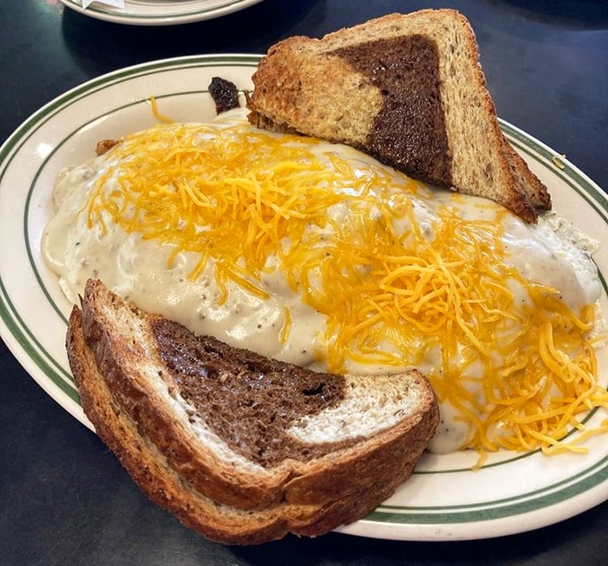 Not all heroes wear capes—some wear cheese. This country scramble comes blanketed in melted cheddar, turning ordinary toast into supporting characters in this breakfast drama.