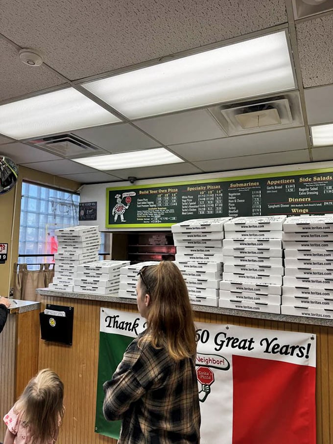 The stacked pizza boxes and "Thank You for 60 Great Years" banner speak volumes about community loyalty that chain restaurants can only dream about.