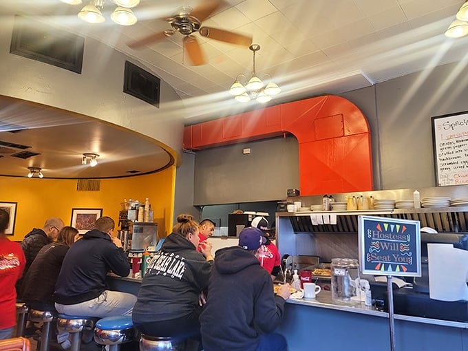 The counter seats—where breakfast philosophers gather to contemplate life's big questions while watching hashbrowns achieve crispy perfection.