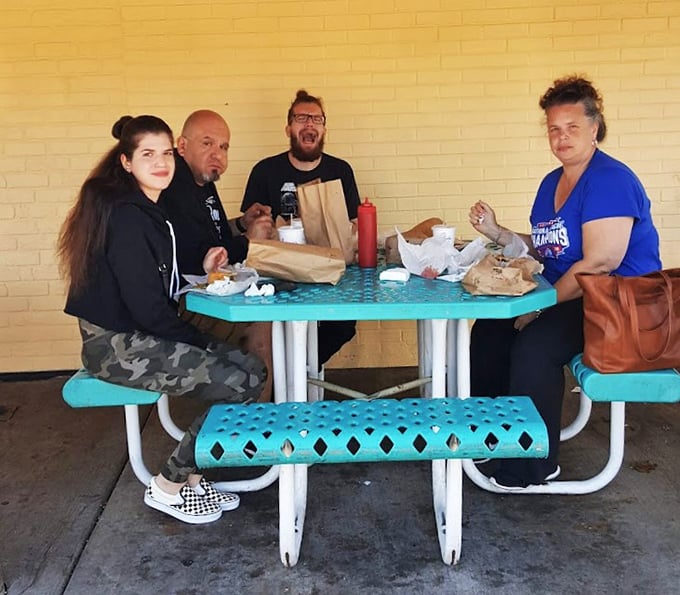 The outdoor picnic tables—where strangers become temporary family, united by the universal language of "this sandwich is worth the mess."