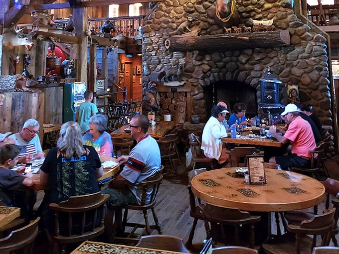 Diners gather beneath the impressive stone fireplace, creating a Norman Rockwell painting come to life – if Norman had appreciated antler chandeliers.