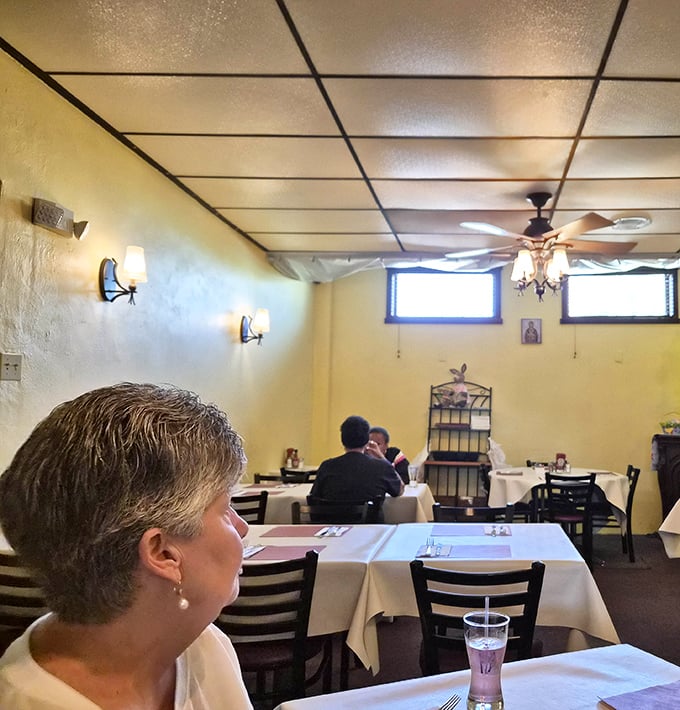 Soft lighting, white tablecloths, and yellow walls create that perfect "neighborhood gem" atmosphere where memories are made between bites.