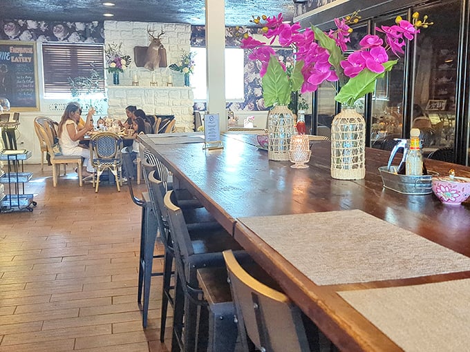 The communal table invites strangers to become friends over shared plates. Those pink orchids aren't just pretty—they're conversation starters.