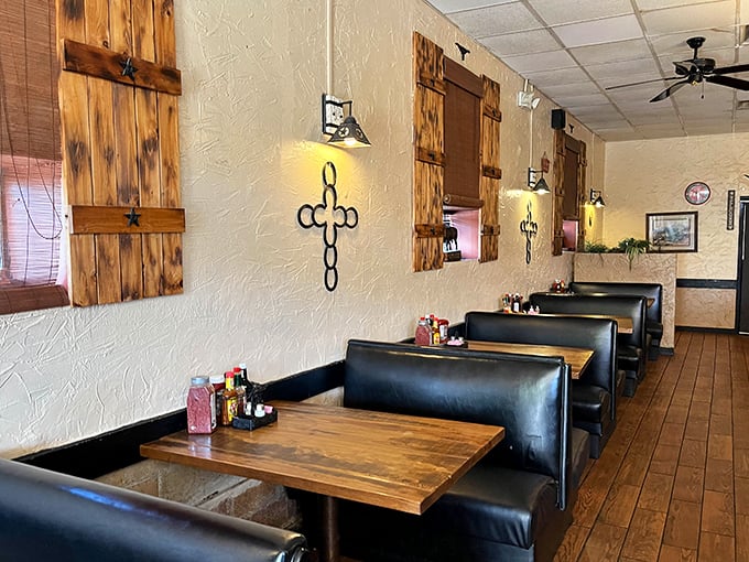 Black leather booths against textured walls with rustic wooden shutters—Texas comfort without trying too hard.