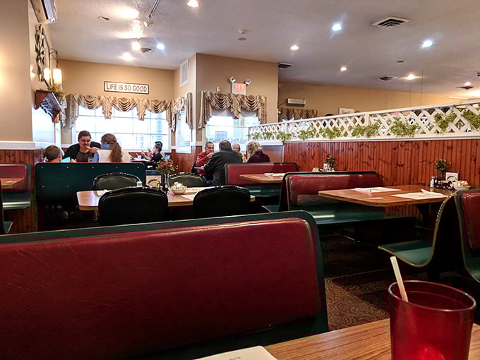 Red booths and wooden accents create that perfect "remember when restaurants felt like this?" atmosphere. Note the "Life is Good" sign – they're not wrong.