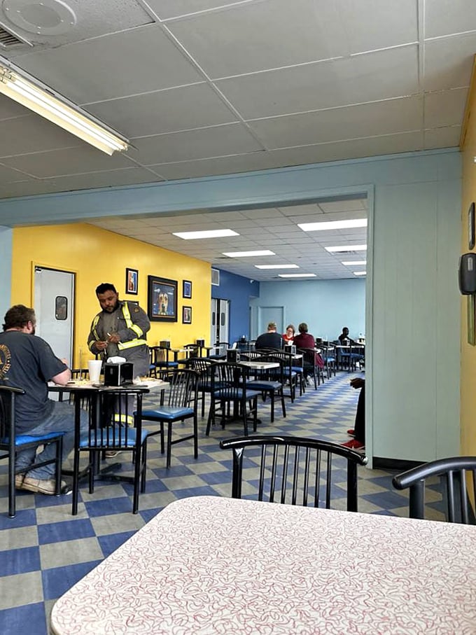 Bright yellow walls and blue accents create a cheerful backdrop for serious eating. Notice nobody's looking at their phones—the food demands full attention.