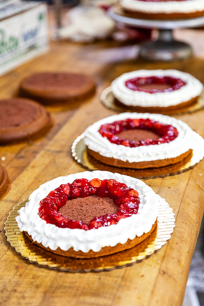The display case of dreams. Where diet plans go to die and happiness is measured in layers of pastry.