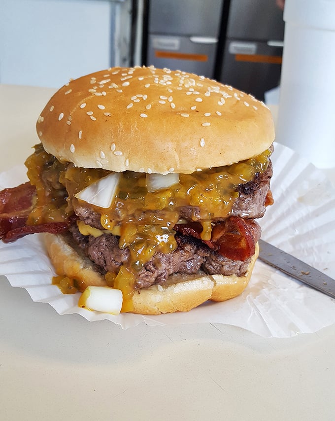 A burger so perfectly stacked it belongs in the Smithsonian, though it would be a crime not to eat this architectural marvel immediately.