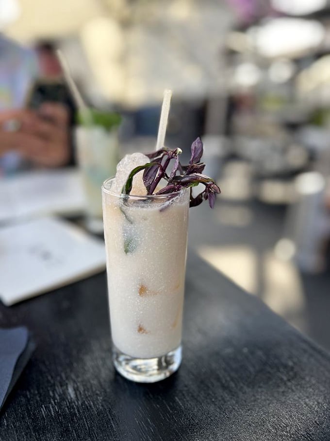 Their signature cocktail arrives looking like a botanical garden in a glass—complete with purple basil garnish.