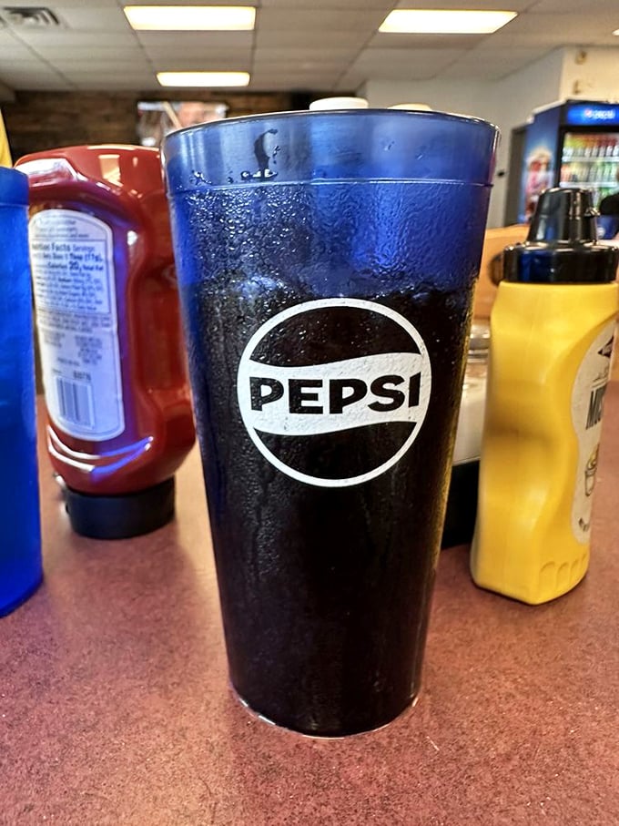 That condensation on the Pepsi glass isn't just moisture – it's anticipation for the perfect burger companion waiting to refresh your palate.